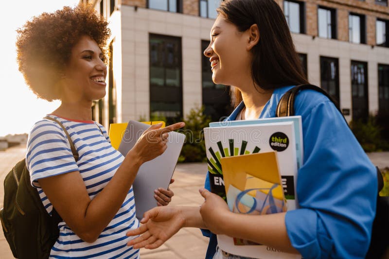 Cheerful Female Students Talking after Classes while Standing Outdoors ...