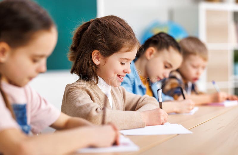 Cheerful Girl Solving Test with Classmates at School Stock Photo ...