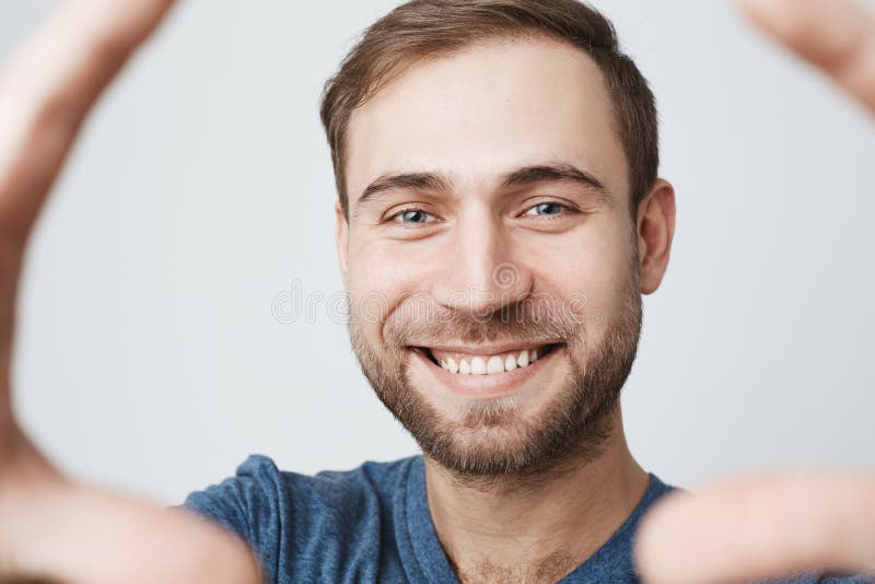 Cheerful Good Looking Young Man In Blue Shirt With Dark Hair Smiling