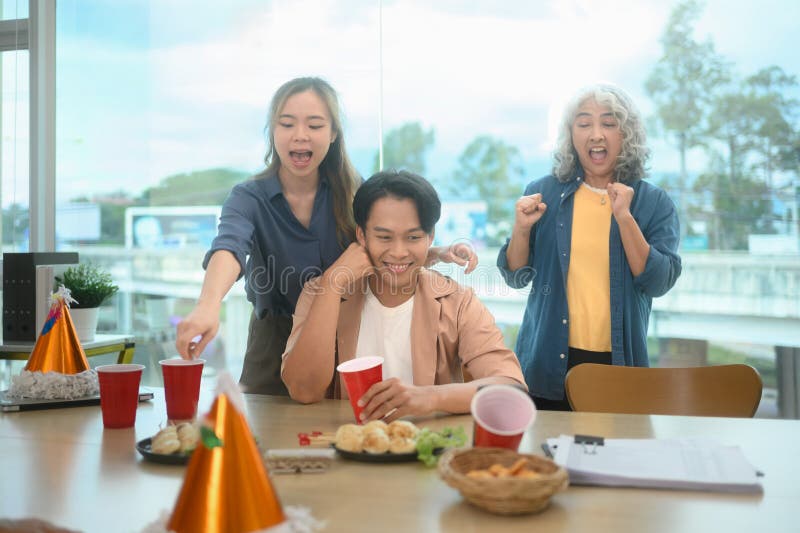 Cheerful Group of Colleagues Enjoying Snacks and Drinks during a Lively ...
