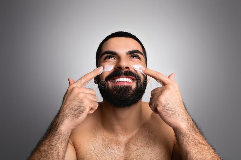 Cheerful Millennial Middle Eastern Man Using Face Cream Stock Photo ...