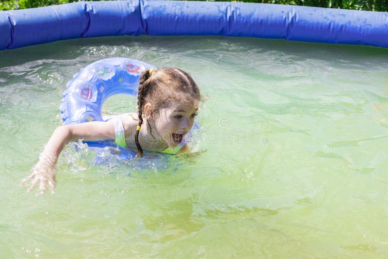 Cheerful Happy Girl Floating On An Inflatable Circle In The Pool