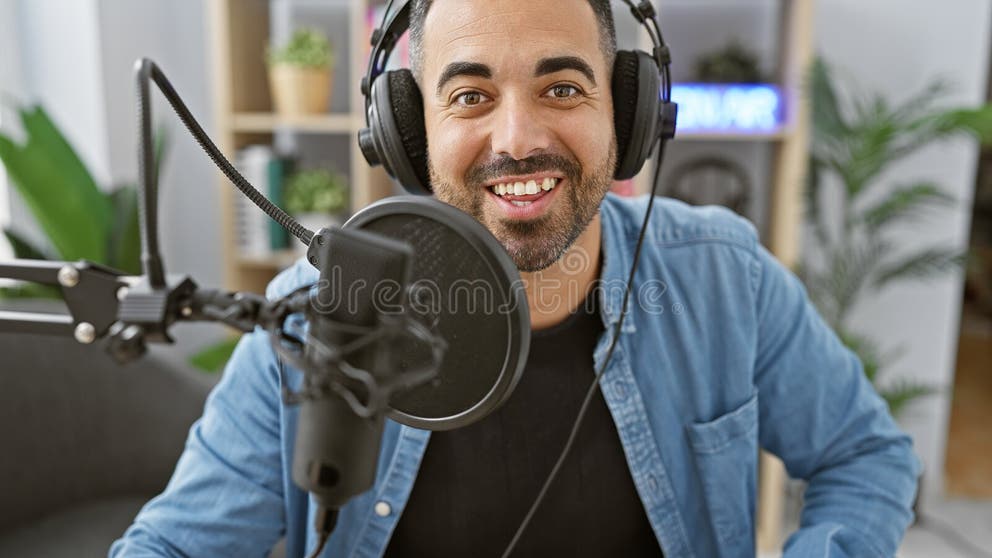 A Cheerful Hispanic Man with a Beard Hosting a Show in a Radio Studio ...