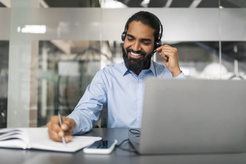 Cheerful Indian Man with Headset Working Online on Laptop Computer ...