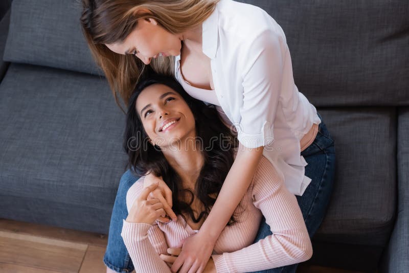 Cheerful Lesbians Hugging And Looking At Stock Image Image Of Home