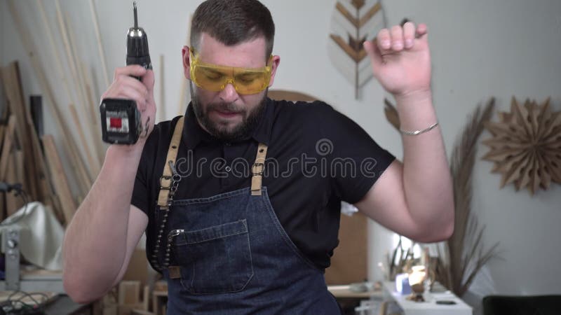 A Cheerful Man is Dancing in a Carpentry Workshop. Funny Working ...