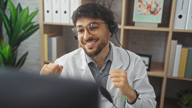 A Cheerful Man in a Headset Celebrates a Successful Moment at His ...
