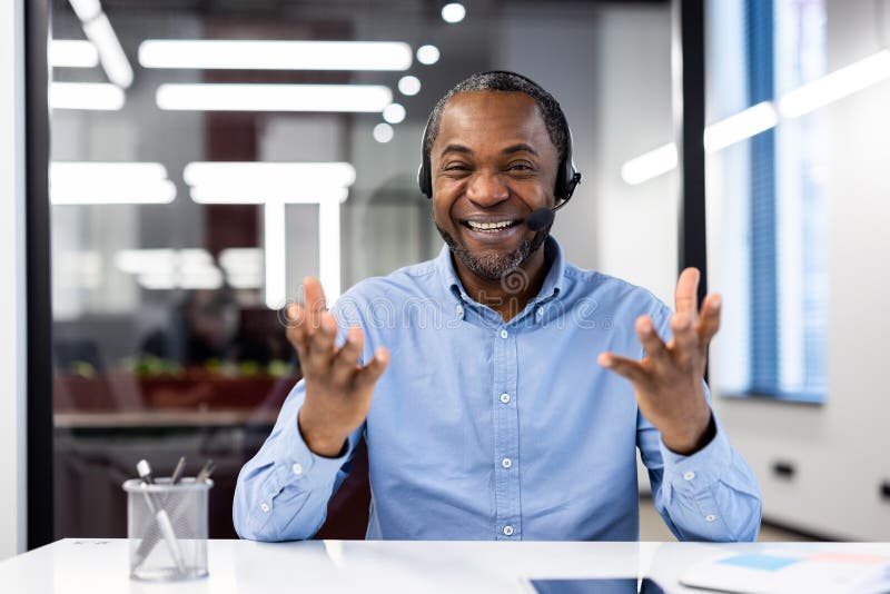 Cheerful Man in Office Using Headset for Video Call, Engaging ...