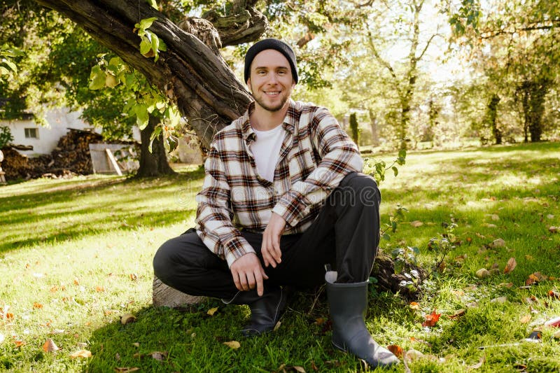 Cheerful Man Sitting Near Tree in Backyard Stock Image - Image of ...