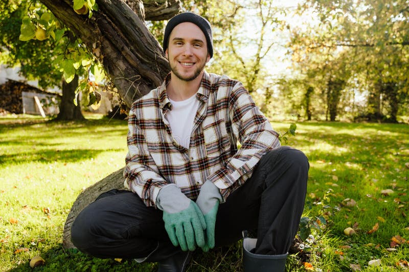 Cheerful Man Sitting Near Tree in Backyard Stock Image - Image of male ...