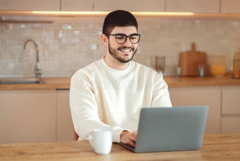 Cheerful Man Sitting at Table Using Laptop Computer Stock Photo - Image ...