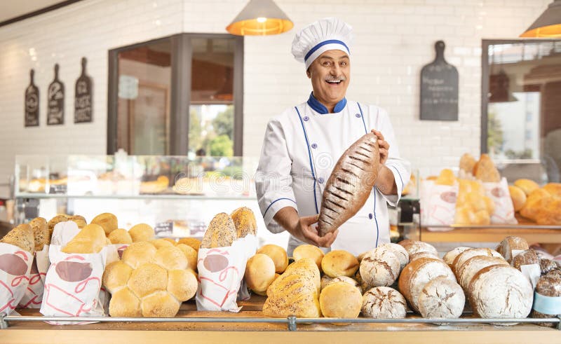 Cheerful Mature Baker Holding Bread in a Bakery Stock Photo - Image of ...