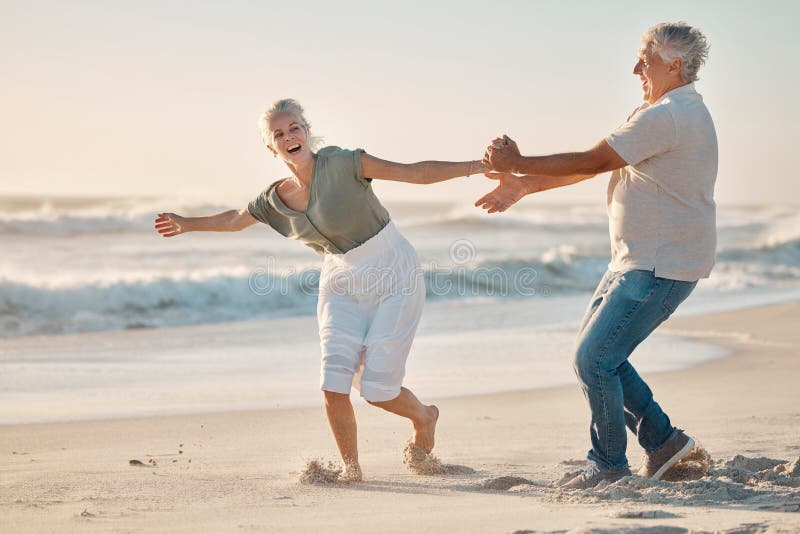 Cheerful Mature Couple Playing On The Beach Senior Couple Having Fun