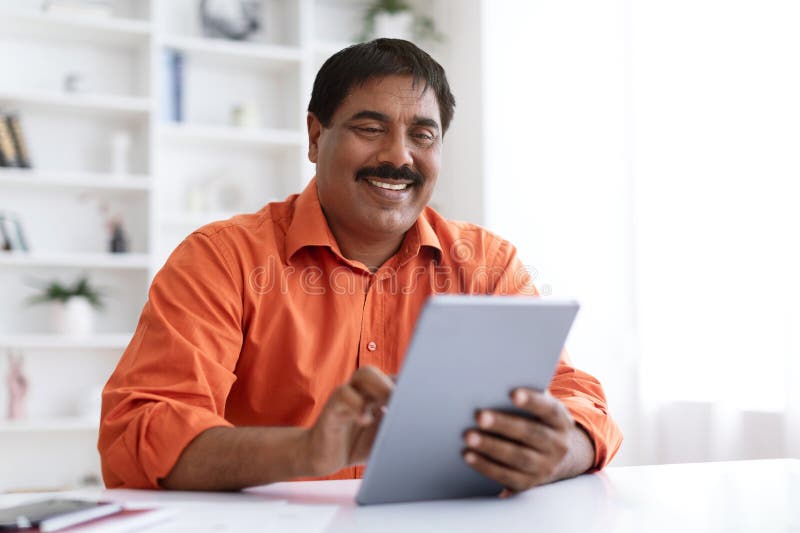 Cheerful Middle Aged Indian Man Typing on Tablet, Planning Startup ...
