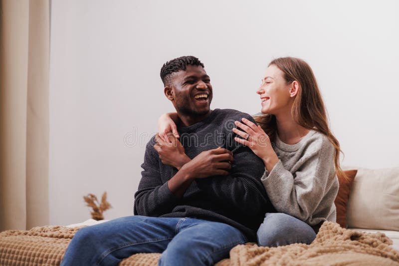 Cheerful Multiethnic Couple Hugging on Bed at Home at Daytime Stock ...