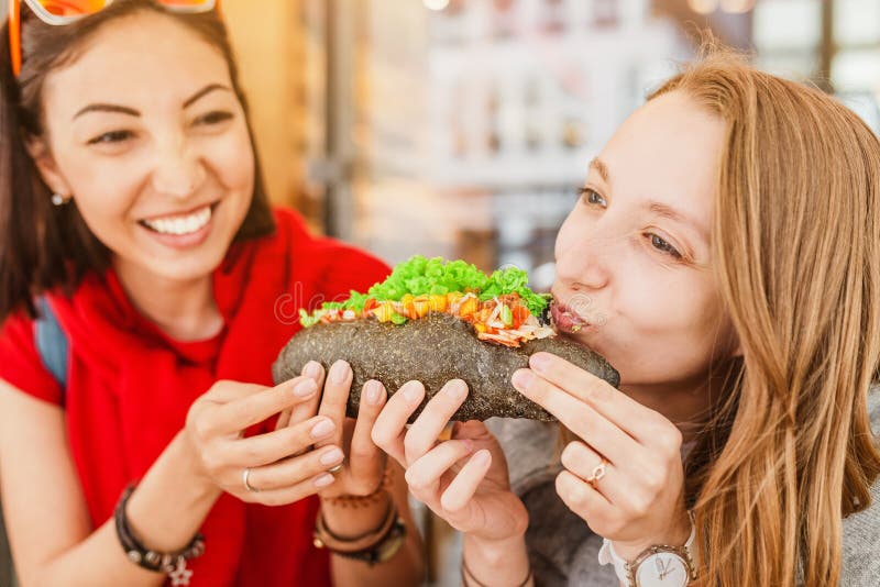 Multiracial Friends Eating Sandwich and Having Fun in a Cafe Stock ...
