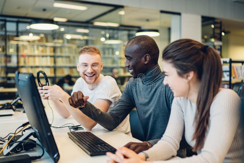Cheerful Multiracial Students Having Fun while Using Computer in ...