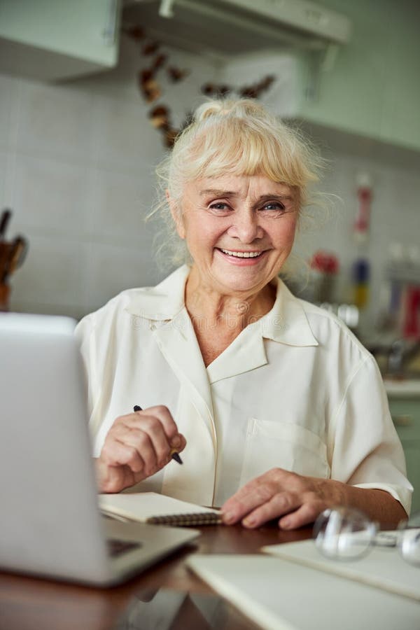 Cheerful Old Woman Using Notebook and Taking Notes at Home Stock Image ...