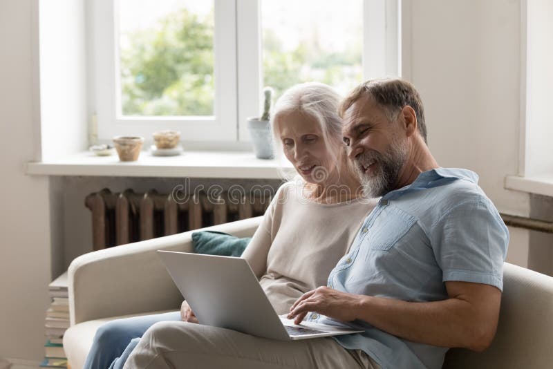 Cheerful Older 60s Married Couple Sitting on Home Sofa Stock Photo ...