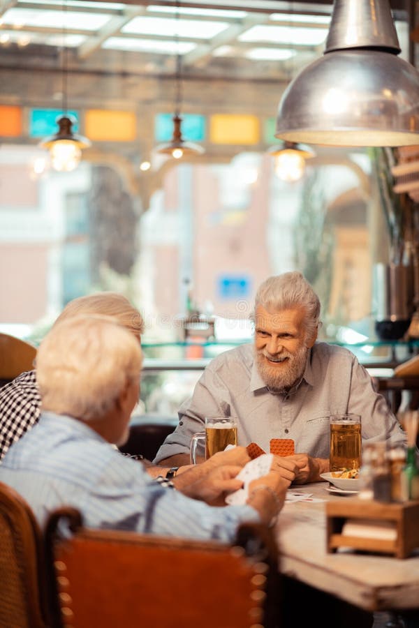 Cheerful Pensioners Playing Cards in the Pub Together Stock Image ...