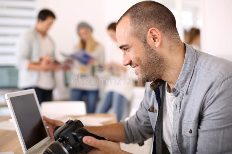 Cheerful Reporter Holding Camera Working on Laptop Stock Photo - Image ...