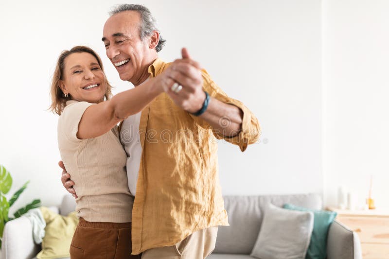 Cheerful Retired Spouses Husband And Wife Dancing And Laughing In