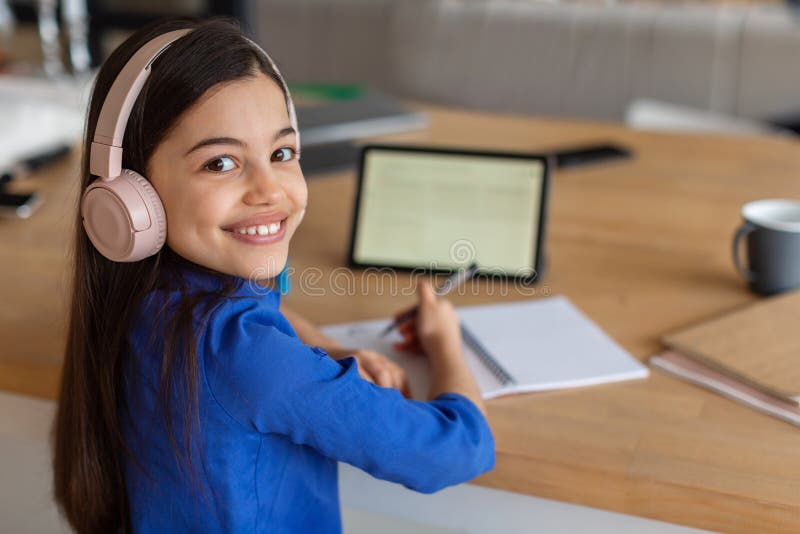 Cheerful Schoolgirl Learning Online Via Digital Tablet Sitting at Home ...