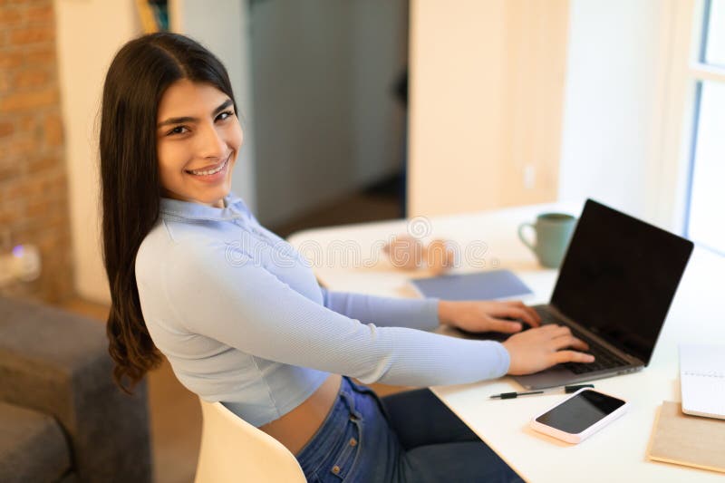 Cheerful Spanish Student Lady Sitting at Desk and Using Laptop Computer ...