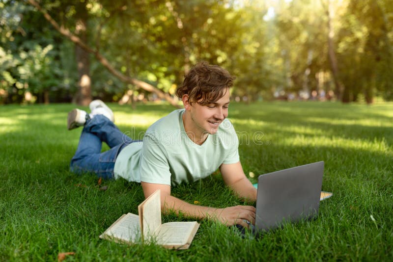 Cheerful Student Guy Doing Homework with Laptop and Book, Resting in ...