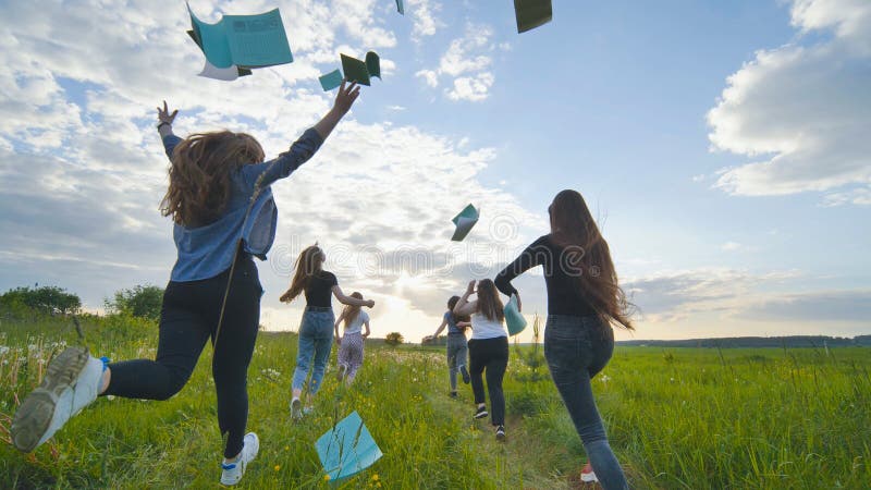 Cheerful Students Run Throwing Notebooks after School at Sunset. Stock ...