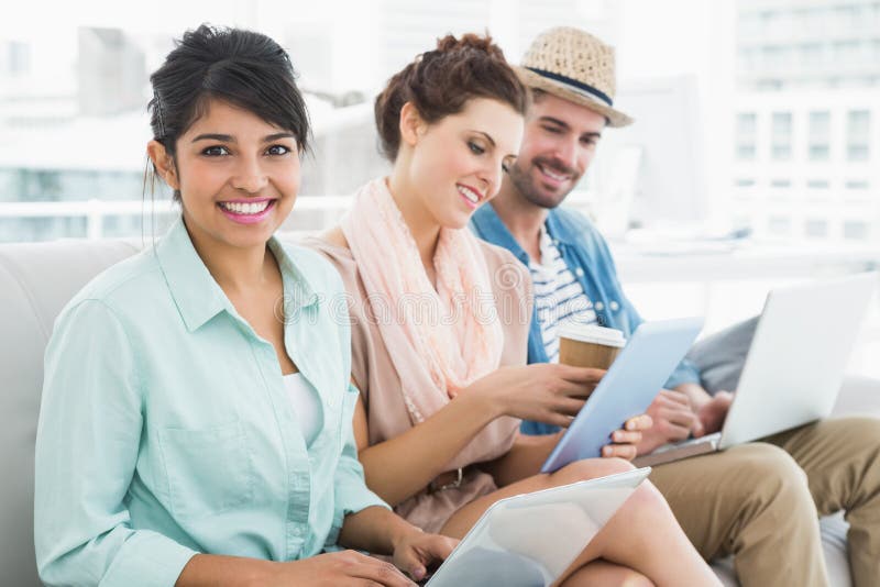 Cheerful Teamwork on Couch Using Laptop and Tablet Stock Photo - Image ...