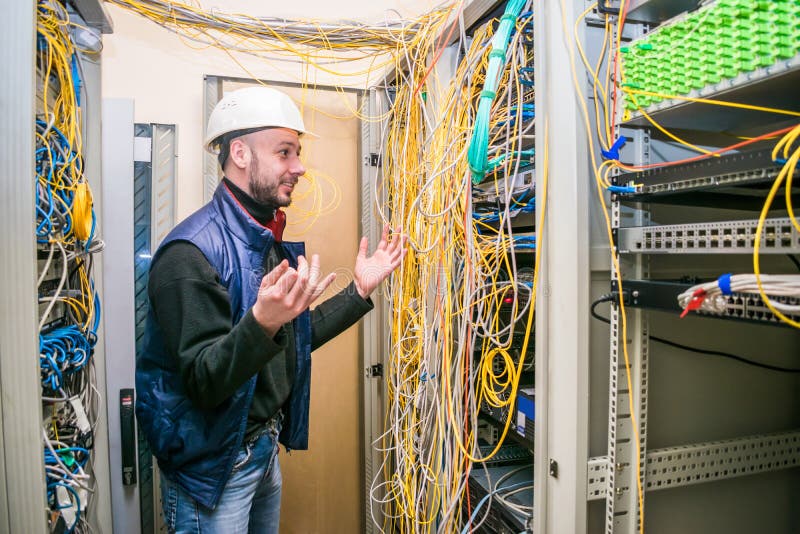 Cheerful Technician Waves His Hand in the Data Center. an Engineer in a ...