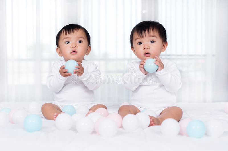 Cheerful Twin Babies Playing Color Ball on Bed Stock Photo - Image of ...
