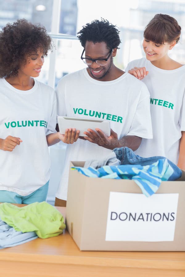 Cheerful Volunteers Looking at a Tablet Pc Stock Photo - Image of ...
