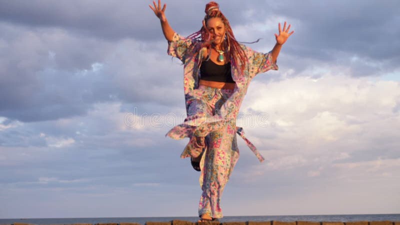 Cheerful Woman with Boho Dreadlocks Dancing Against Sea Background ...