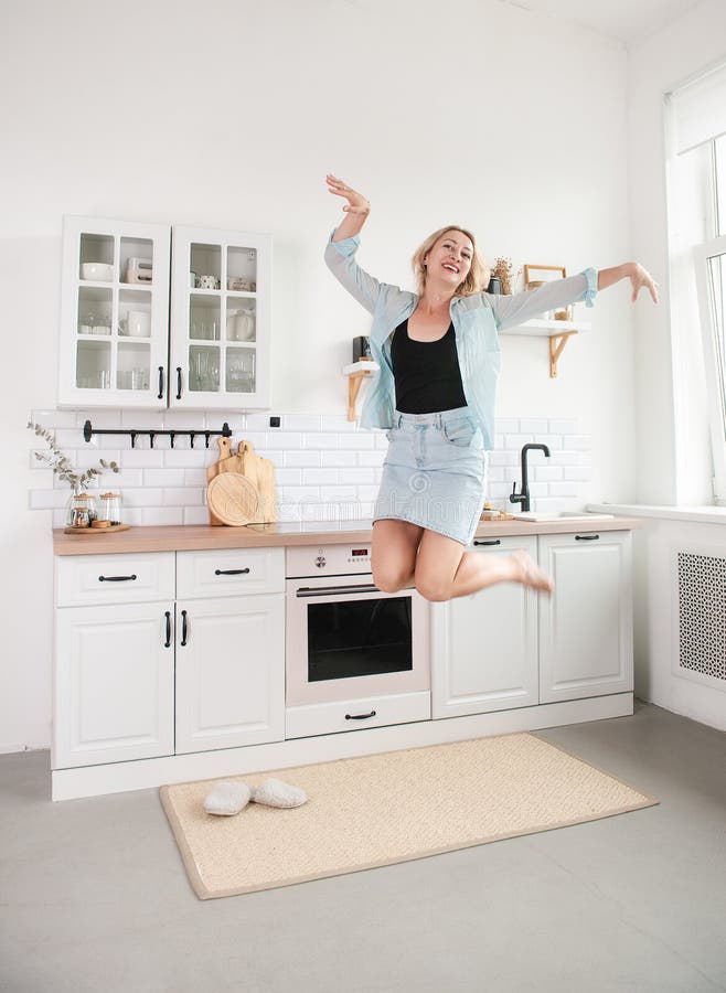 Cheerful Woman Jumping and Dancing in the Kitchen Stock Photo - Image ...