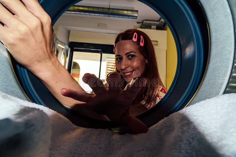 Woman Loading Clothes into Washing Machine at Laundromat Stock Photo ...