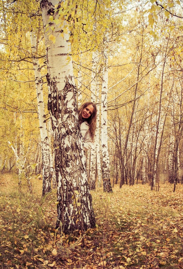 Cheerful Woman Looks Out from Behind a Tree Stock Image - Image of ...