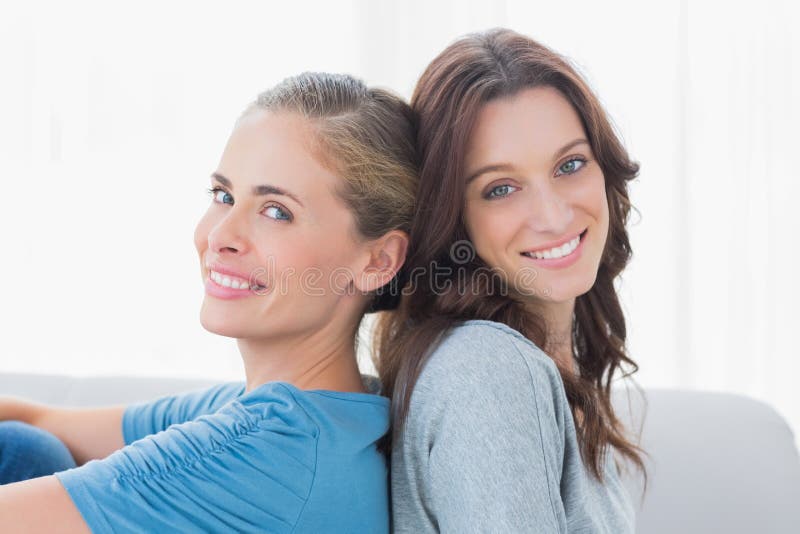 Cheerful Women Back Against Back and Looking at Camera Stock Image ...