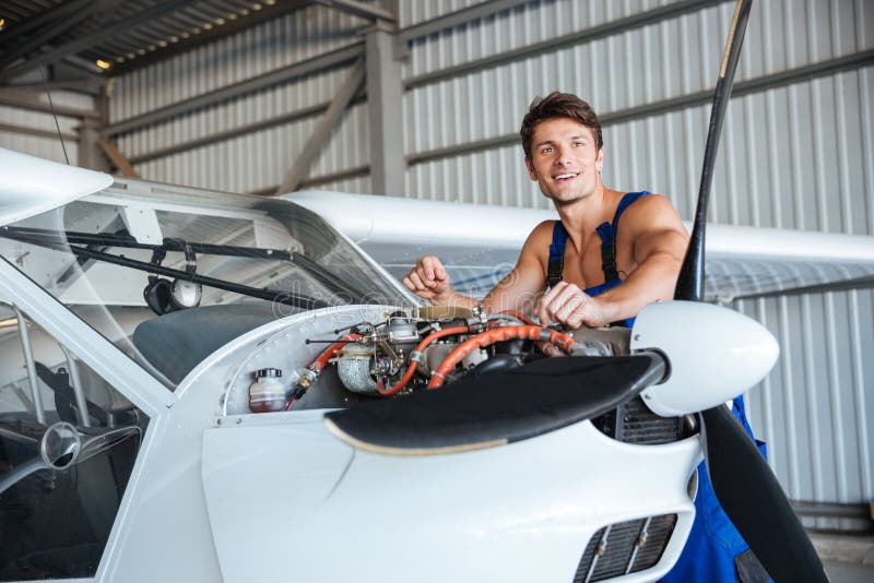 Cheerful Young Air Mechanic Working with Small Plane Stock Image ...