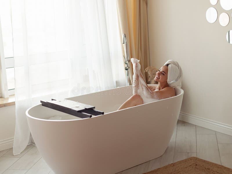 Caucasian Beautiful Woman Lying In Bathtub With Foam Taking Bath In