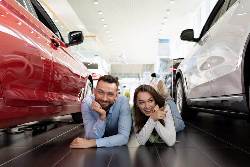 Cheerful Young Couple Fooling Around Lies on the Floor in a Car ... Cheerful Young Couple Fooling Around Lies on the Floor in a Car ...