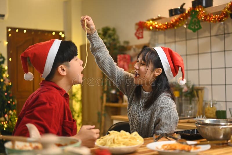 Cheerful Young Couple Having Fun Sharing Spaghetti in a Festively ...