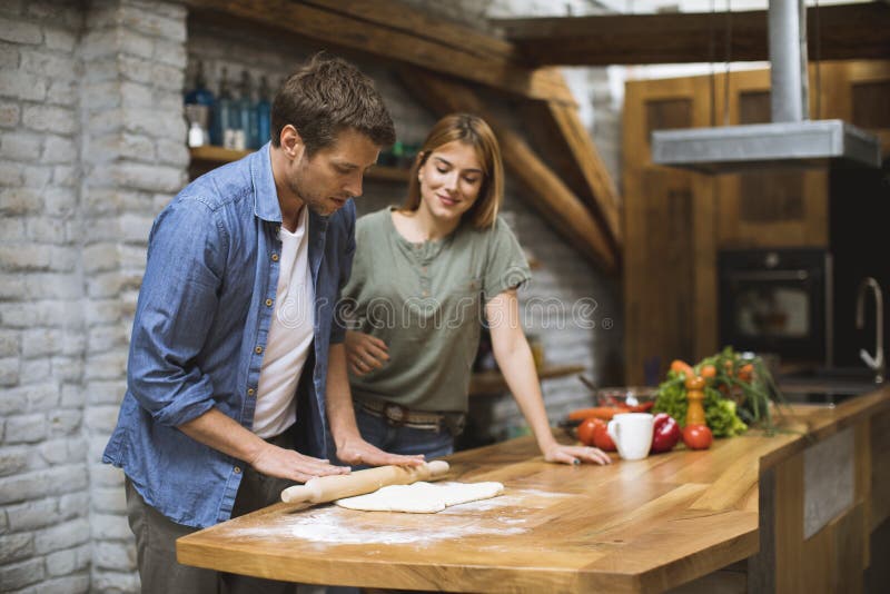Young Couple Making Pizza in Rustic Kitchen Together Stock Photo ...