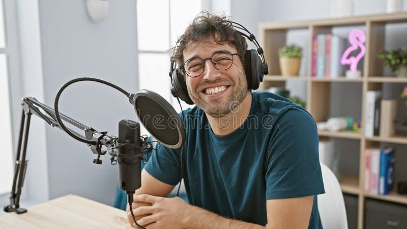 A Cheerful Young Man with Headphones in a Modern Radio Studio Setting ...