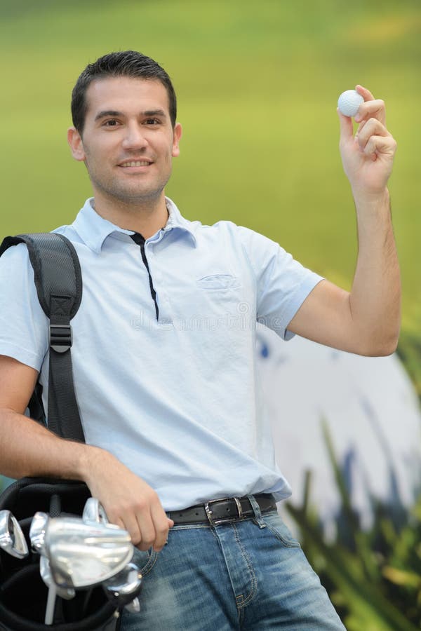Cheerful Young Man Showing Golf Ball while Standing on Field Stock ...