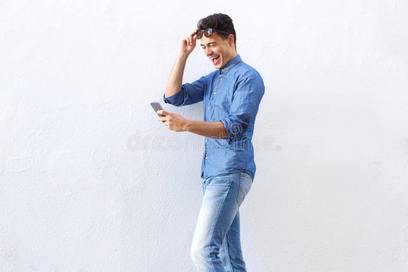 Cheerful Young Man Walking and Reading Text on Cell Phone Stock Photo ...