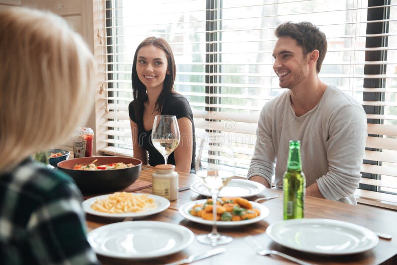 Cheerful Young People Enjoying Meal while Sitting at the Dinning Table ...