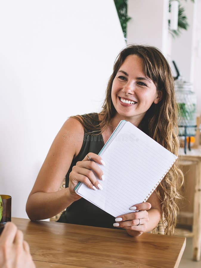 Cheerful Young Pretty Woman Holding Notepad while Siting with Man ...