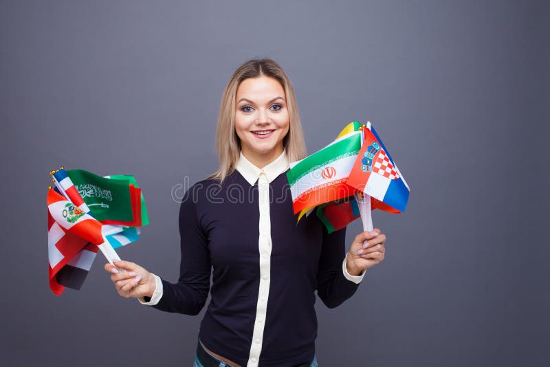 Cheerful Young Woman with a Large Set of Flags of Different Countries ...